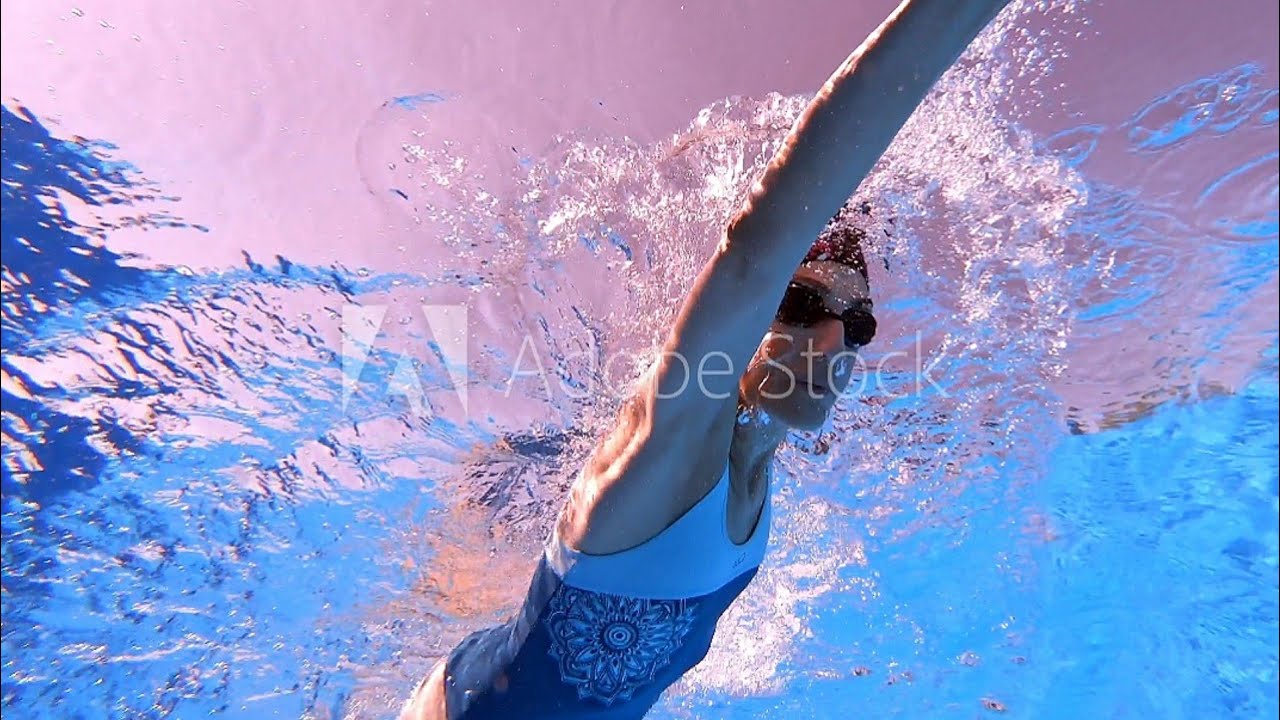 Underwater bottom view of sport woman swimming crawl style in clear ...