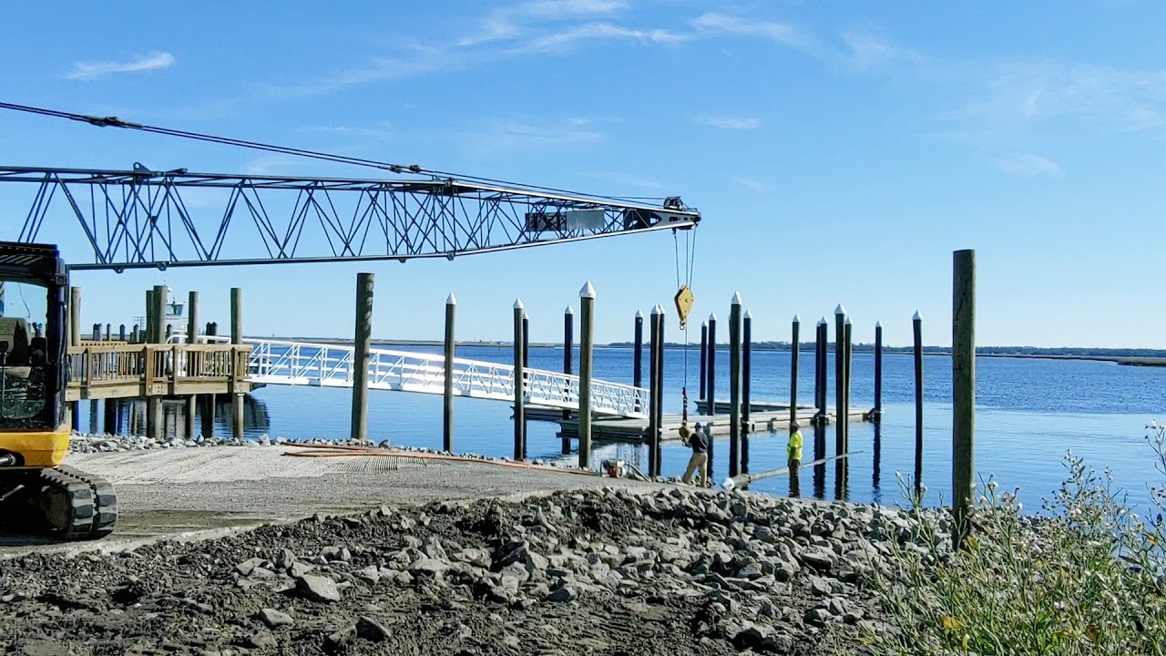 Crane lifting a dock pylon run into by a boat. - YouTube