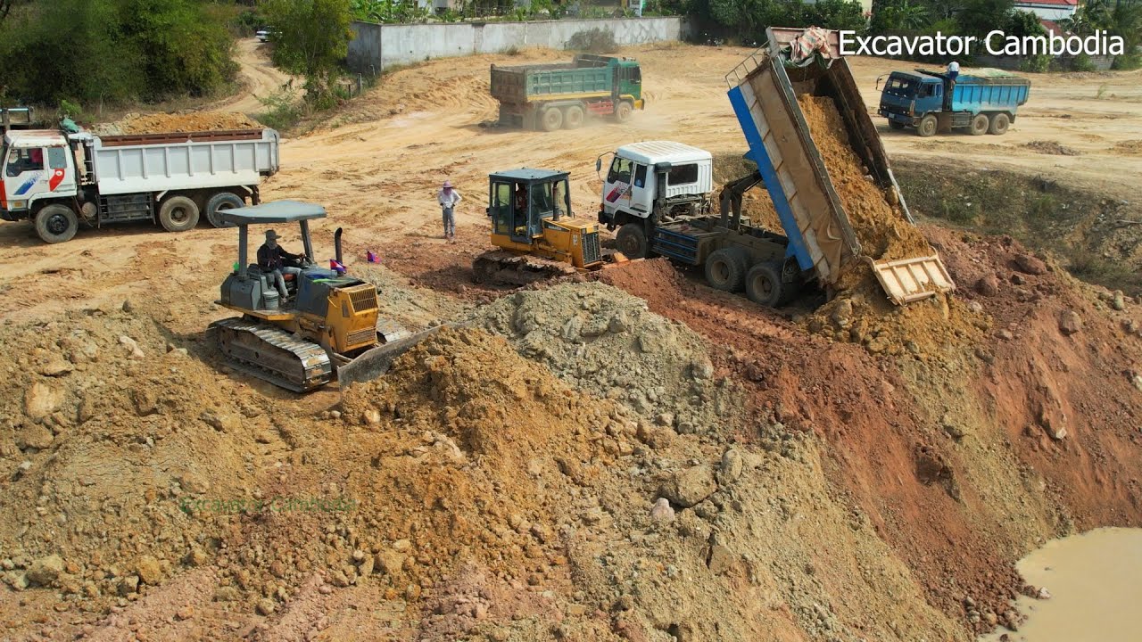 Filling Earth Pit By Dump Truck Unloading Soil And Bulldozer Working ...