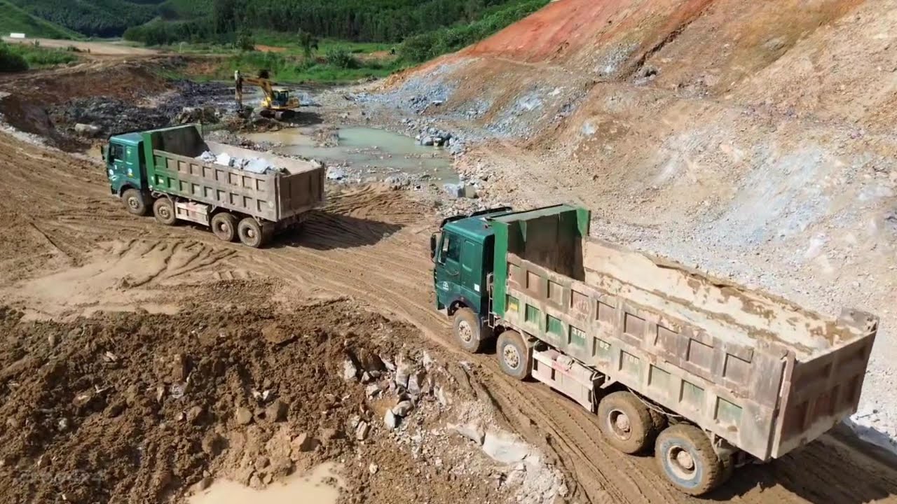 Heavy-duty dump trucks hauling soil at the construction site – power ...