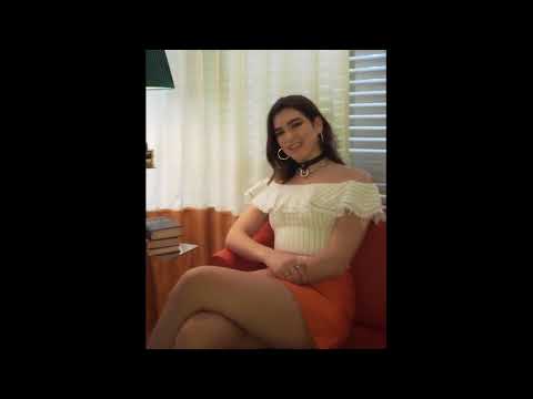 Dua Lipa Bare Crossed Legs in Orange Skirt