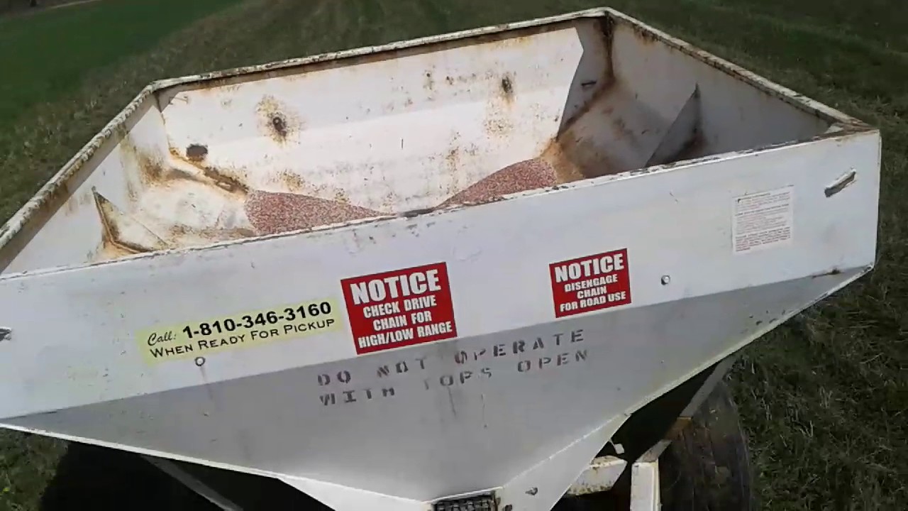Spreading fertilizer on a hay field with a Farmall 560 - YouTube