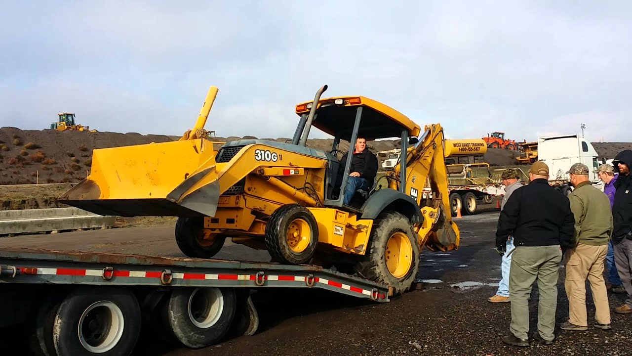 Damon loading a Backhoe on a flatbed - YouTube