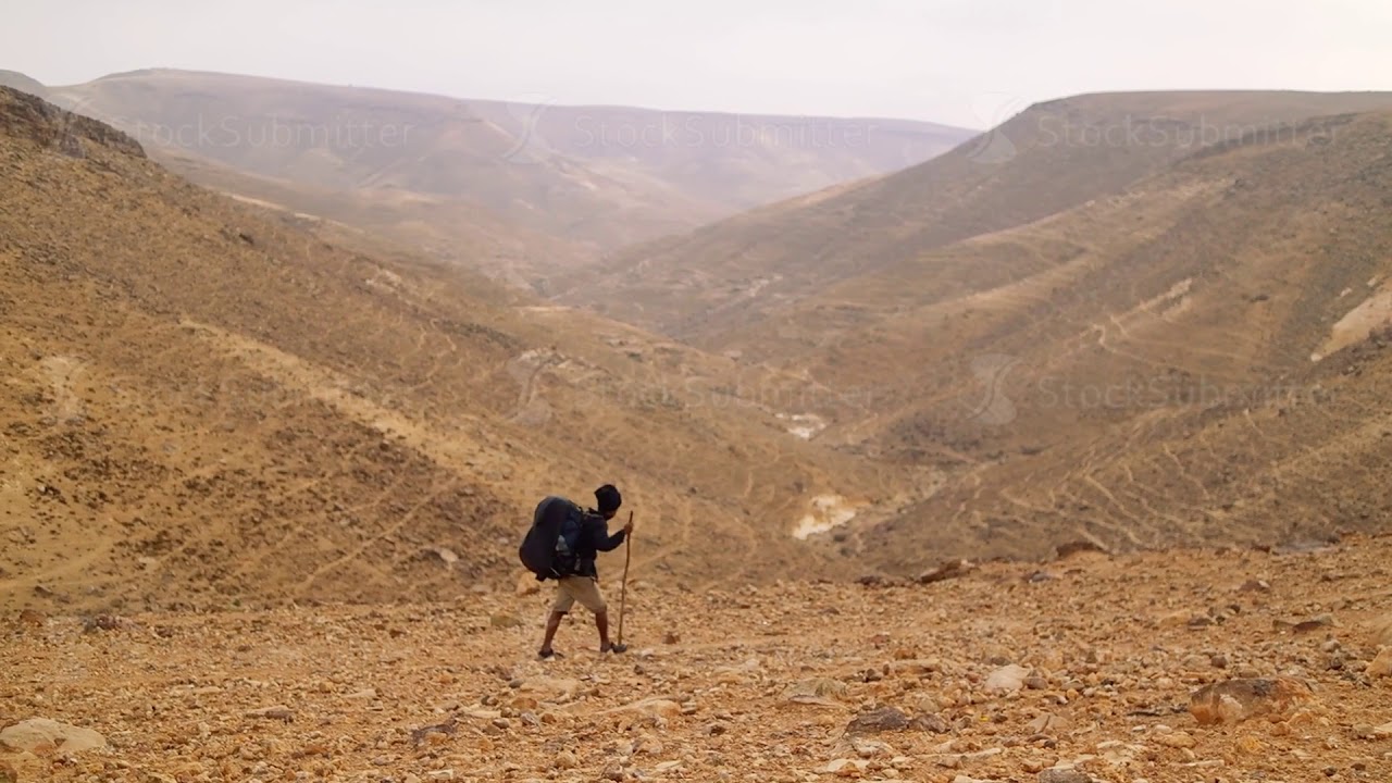 african american young man Traveler with Hiking backpack walk in desert ...
