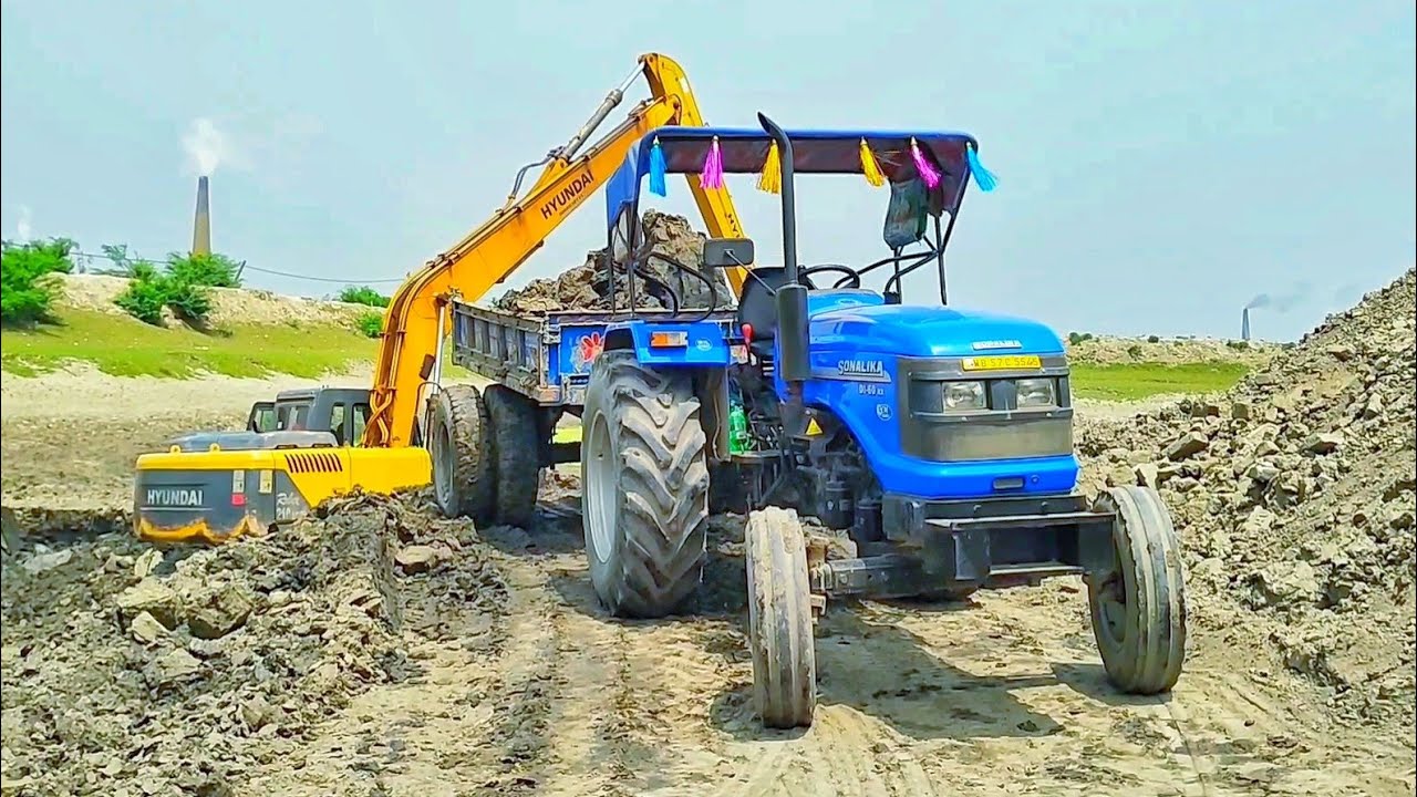 JCB Hyundai 210 long boom Machine loading mud in Mahindra and Sonalika ...