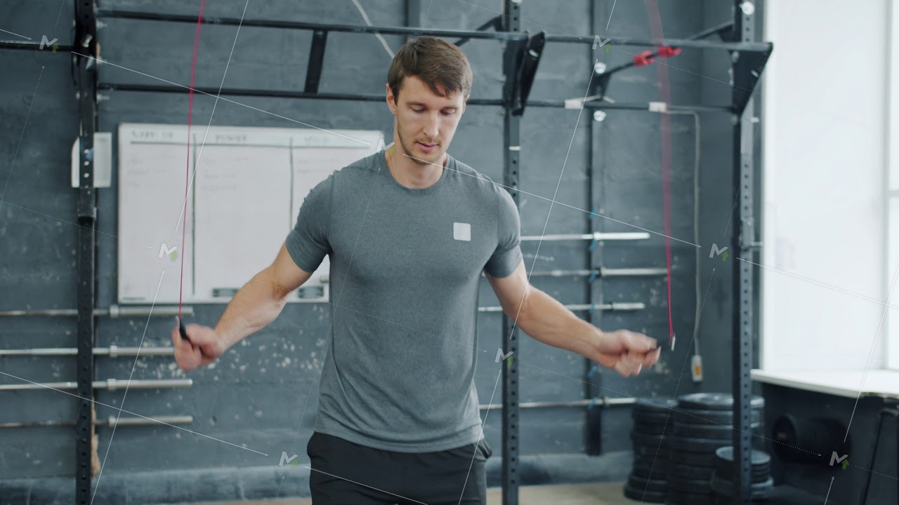 Slow motion of fit guy skipping with jump rope in modern gym enjoying ...