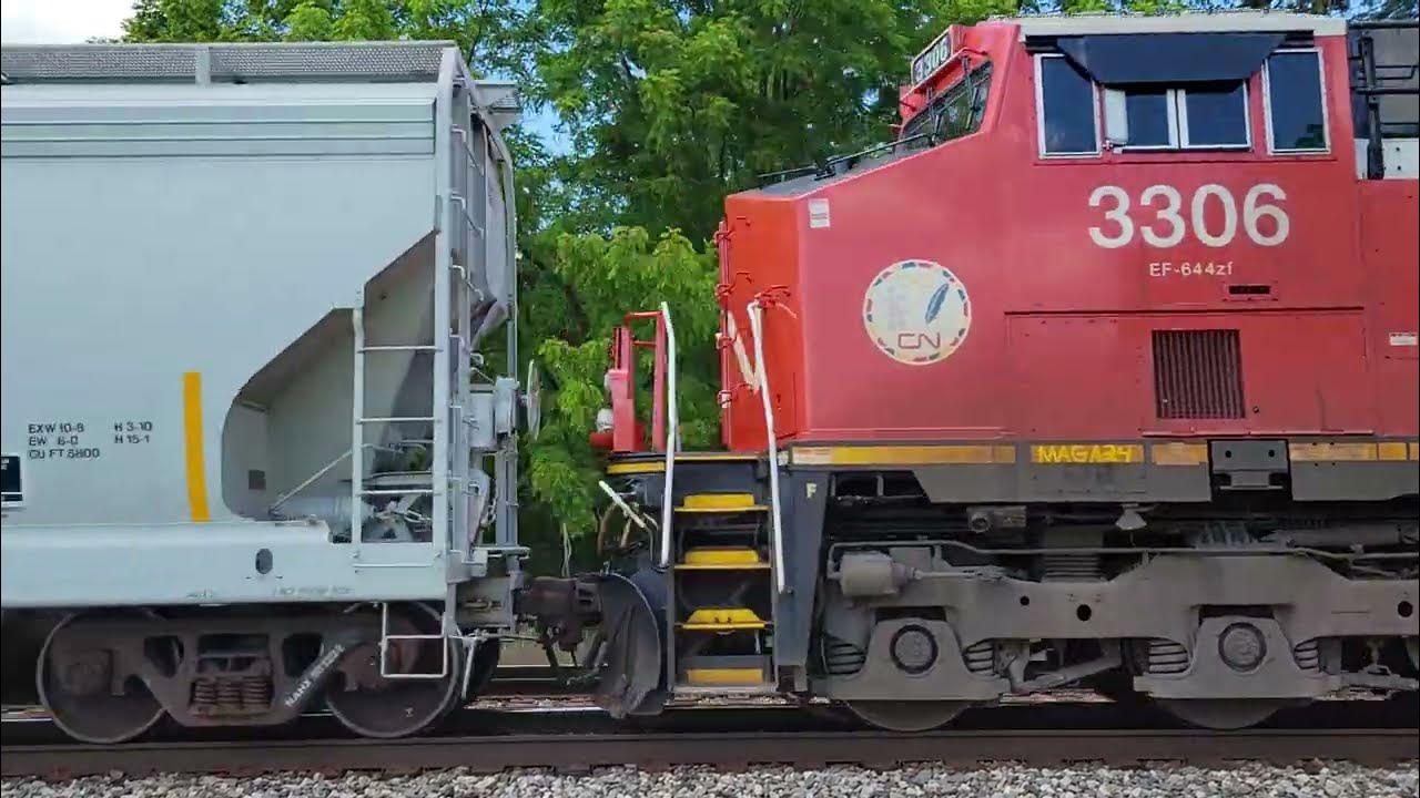 CN EJ&E 3023, 3306 move an Eastbound train with BN hoppers, BC RAIL gondola past Vicksburg, MI ...