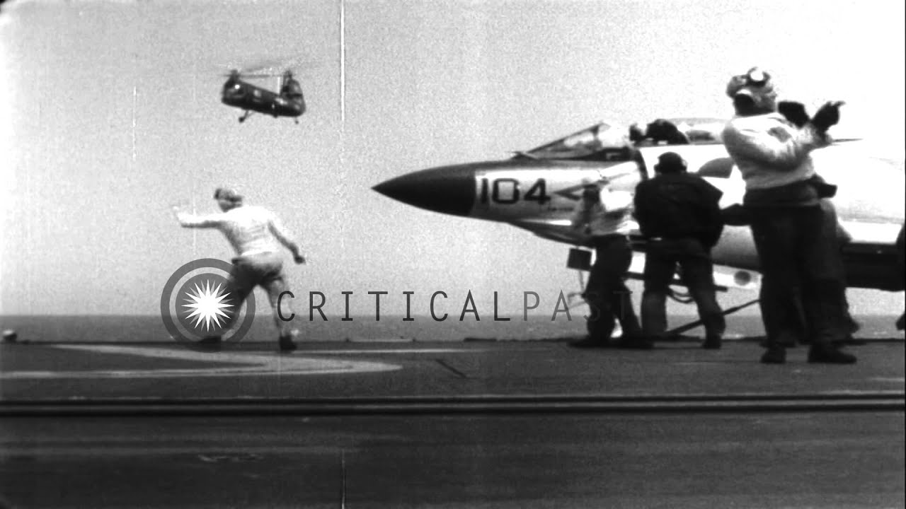 Helicopters and fighter jets are catapulted as a catapult officer gives ...