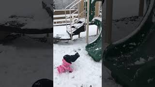 Little girl in pink jacket goes down green slide at playground. then ...