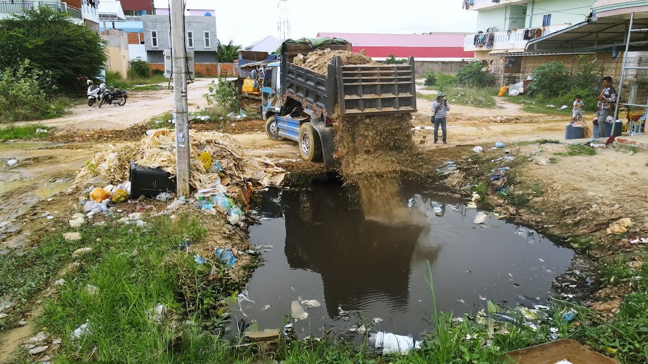 Dump Truck dumped soil dirt into a flooding | Process Captured By ...