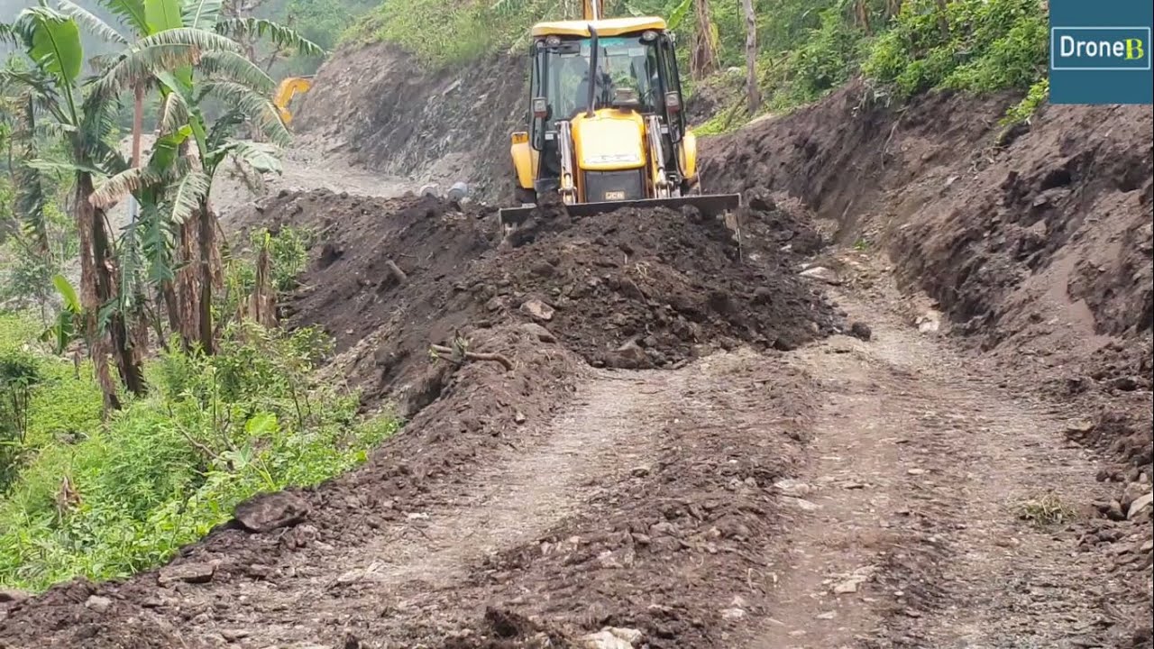 Hilly Road Leveling and Removing Dirt after Excavator-Backhoe Loader ...