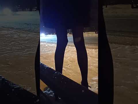 Crossdresser at bus stop, waiting for taxi in stockings and mini skirts, high hells. Public walking