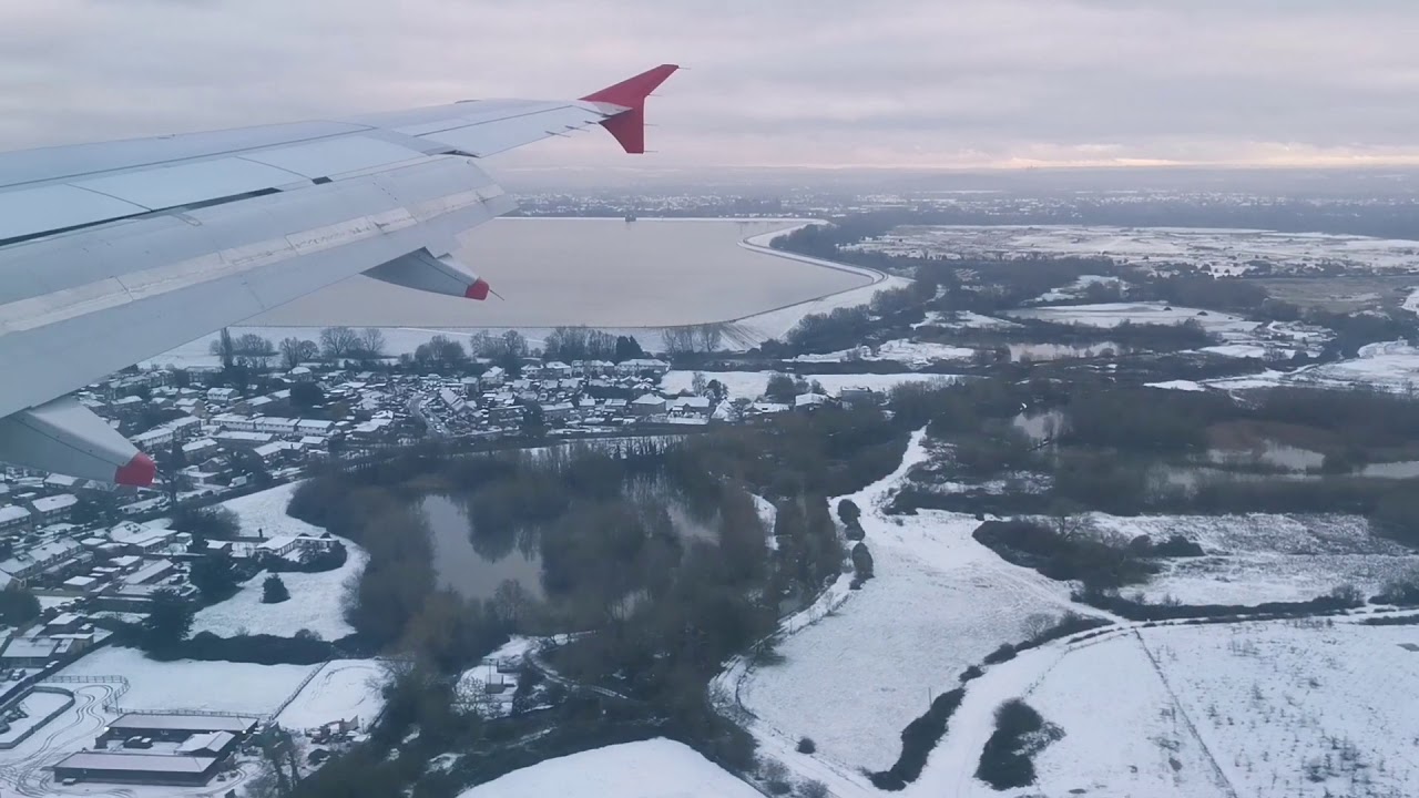 Flying via the clouds and landing in a snow covered London Heathrow ...