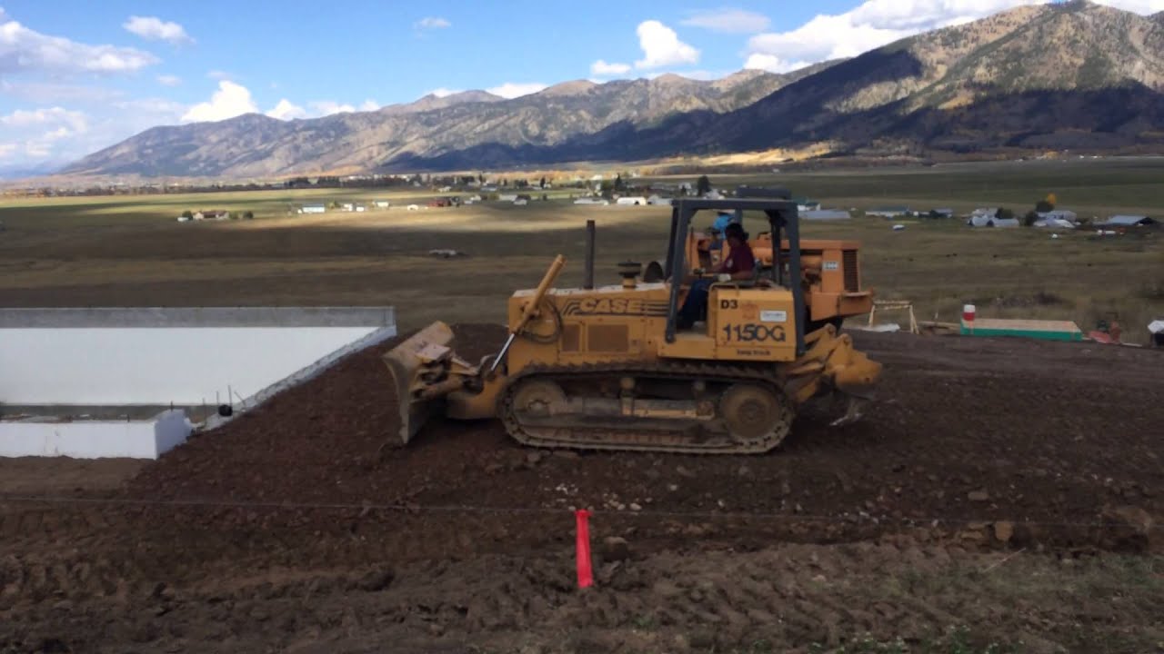 Dozer and roller backfilling around the foundation - YouTube