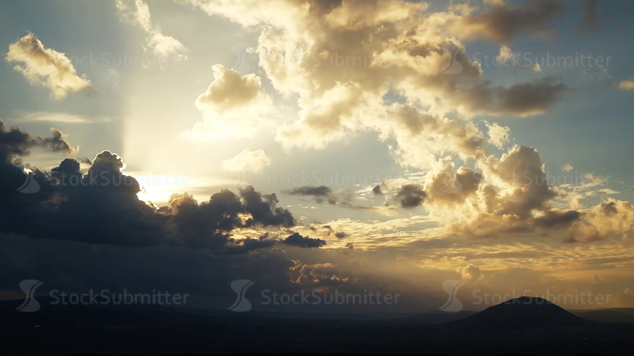 Rain clouds at wild field at spring. Sun's rays breaking through the ...