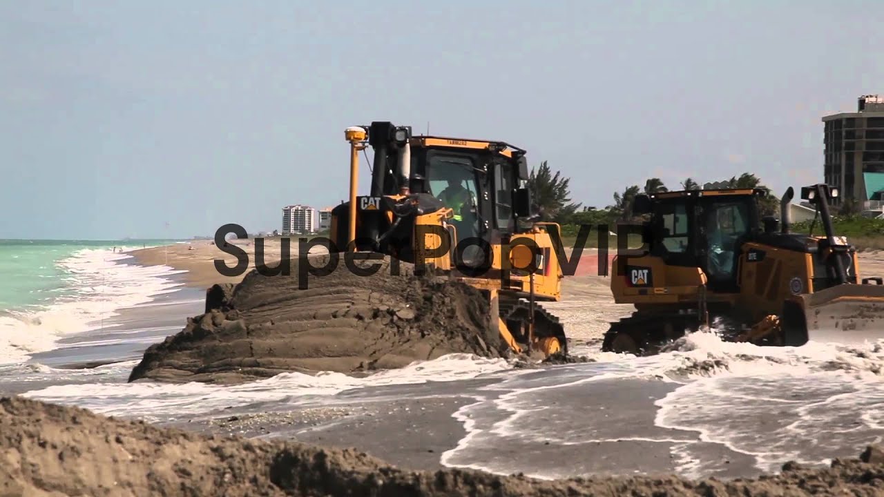 Long shot of two bulldozer pushing sand on the beach. A b... - YouTube