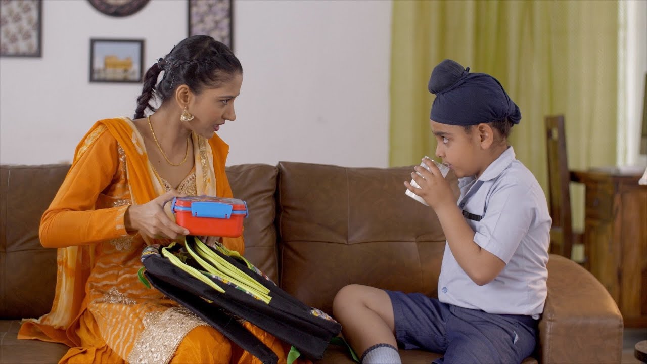 Indian beautiful mother happily packing her son's backpack for ...