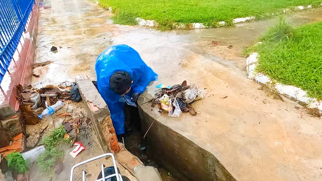Unclogging Trash Rack While Raining Picking Up Garbage In Culvert Drain ...