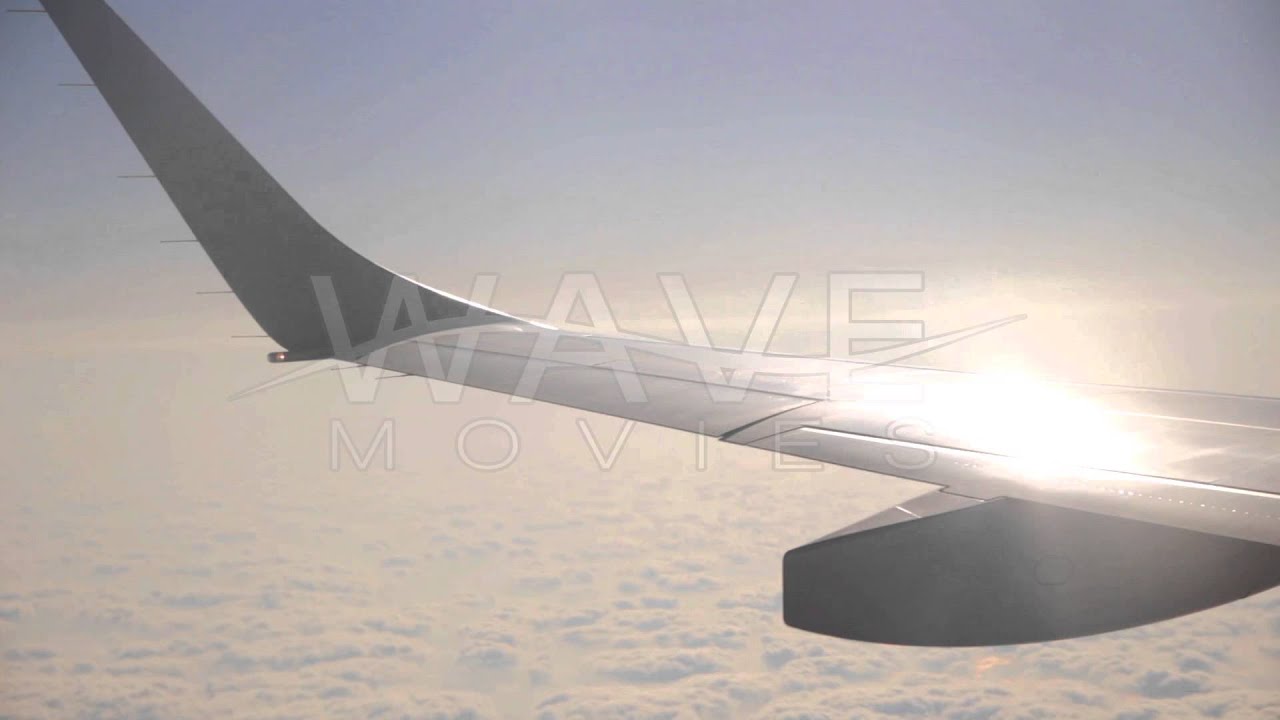 Aerial shot of an airplane wing over the sea - YouTube