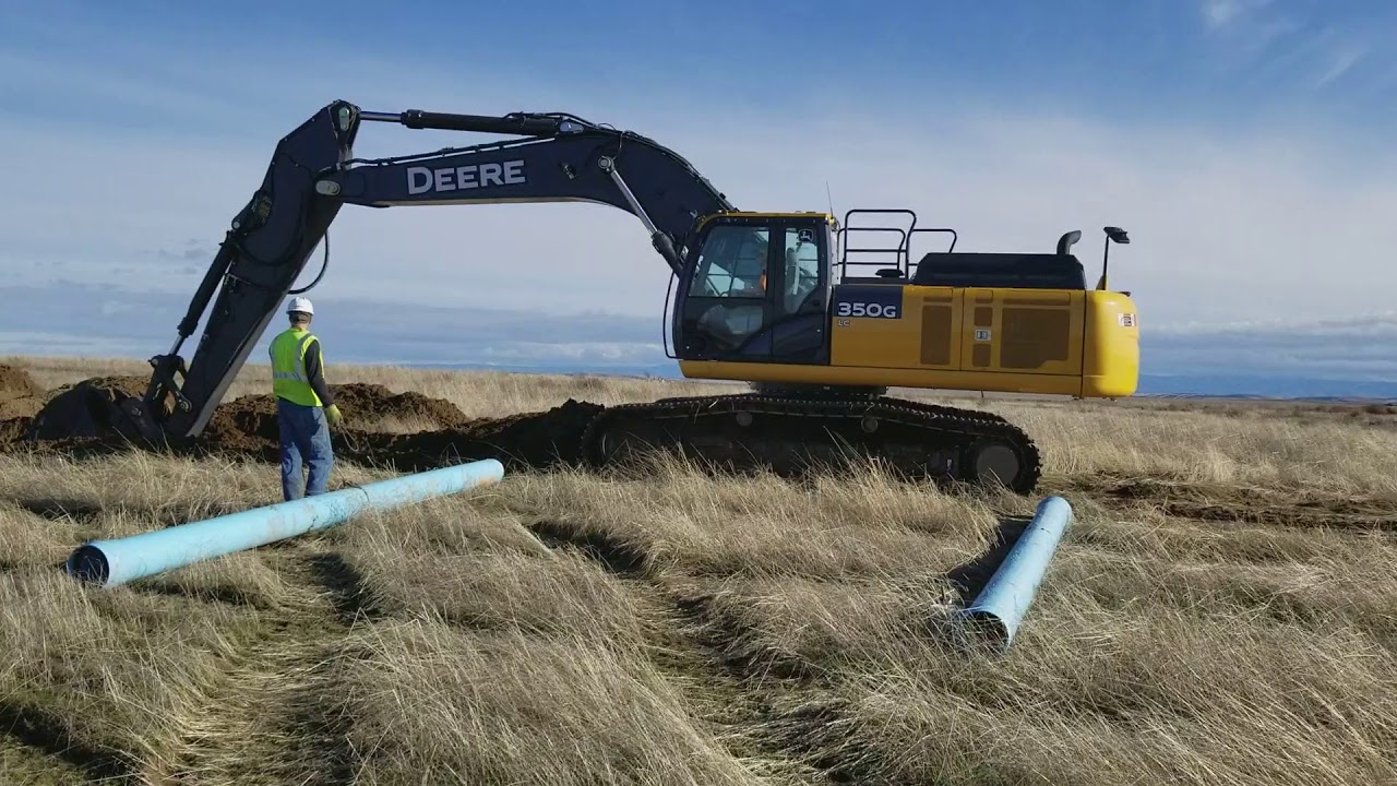 John Deere 350G excavator digging and setting pipe - YouTube