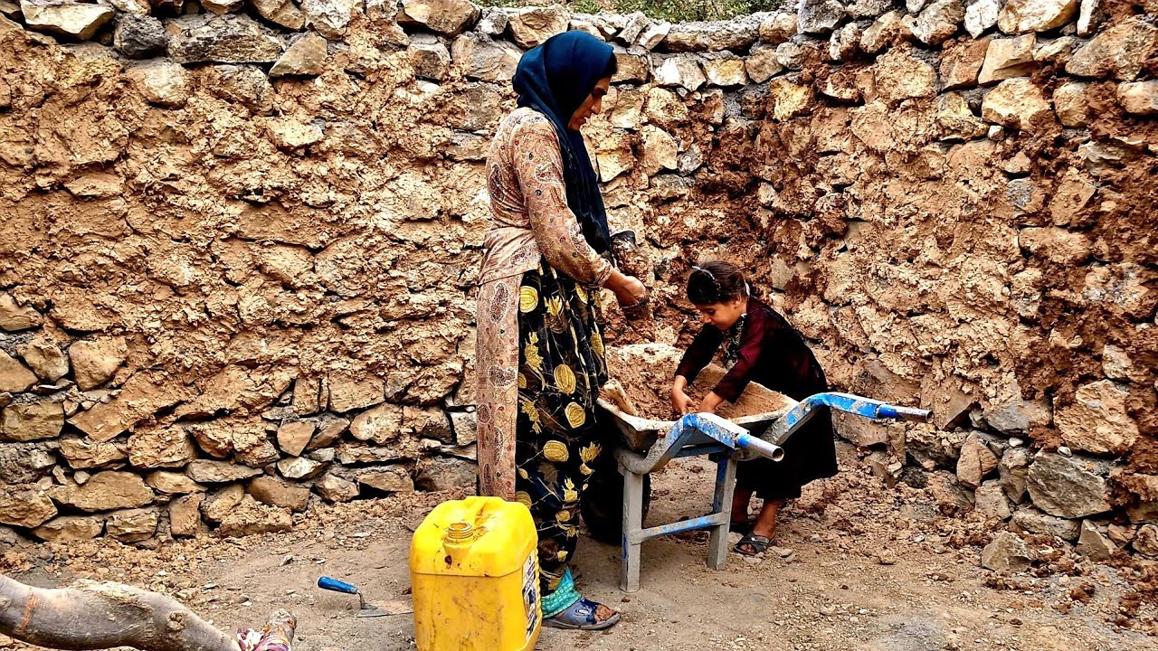 Mother and daughter help each other build a house in the mountains ...