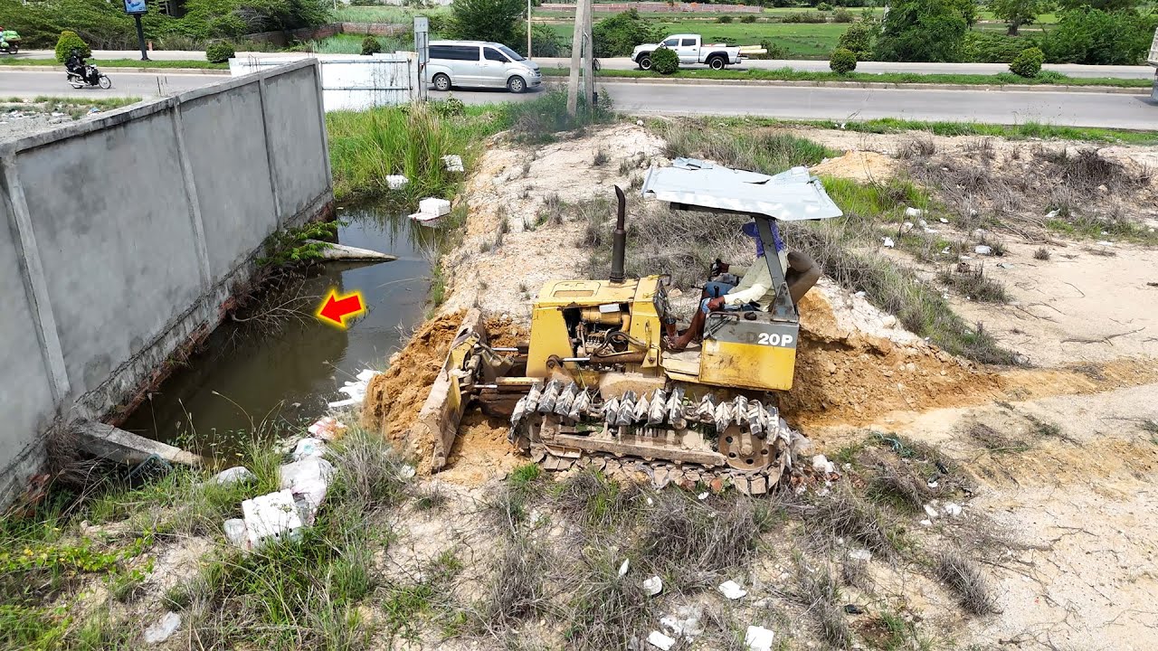 Great Bulldozer filling up over puddles and leveling old land with old ...