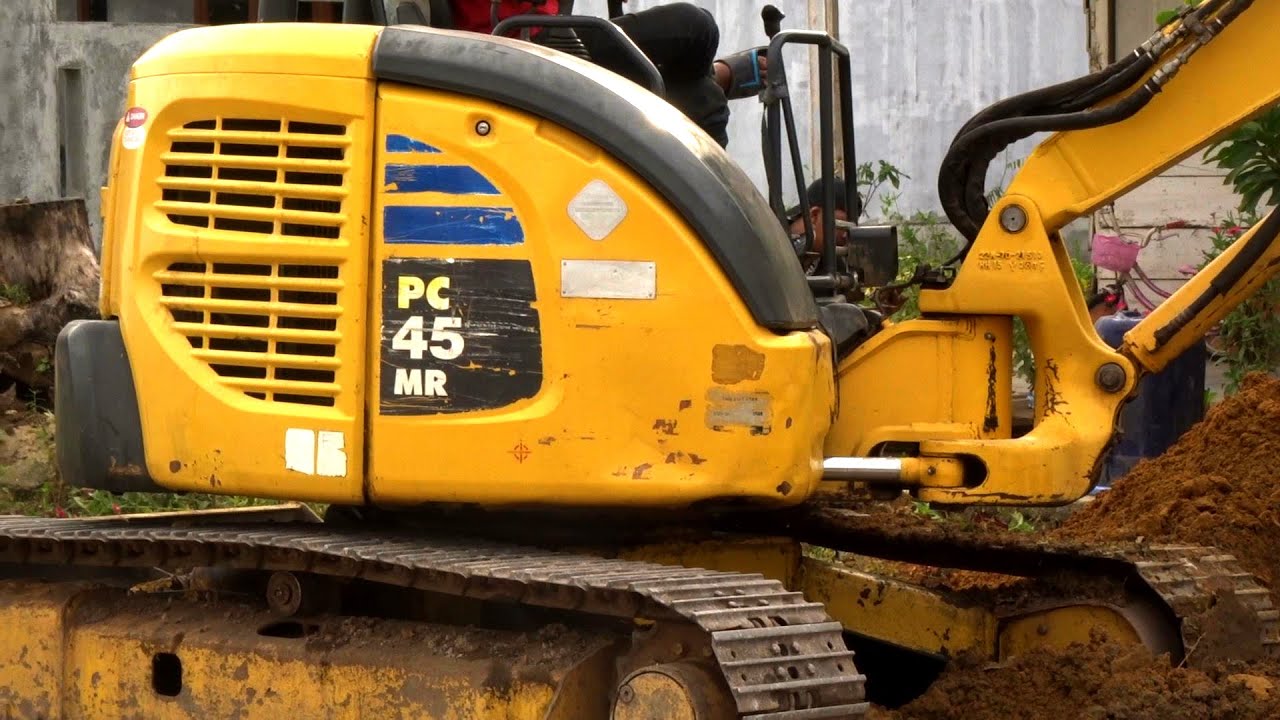 The work of the Komatsu PC 45 excavator digging a water drainage ...