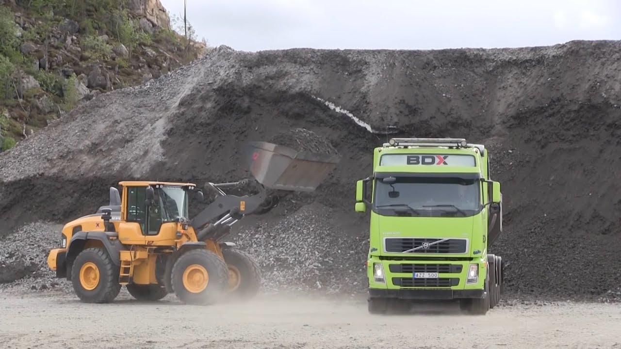 Volvo L110H loading Volvo FH trucks in a quarry - YouTube