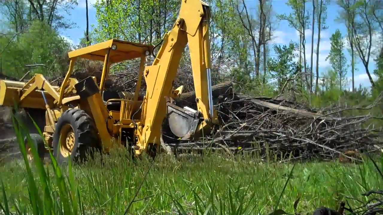 Backhoe Piling Trees - YouTube