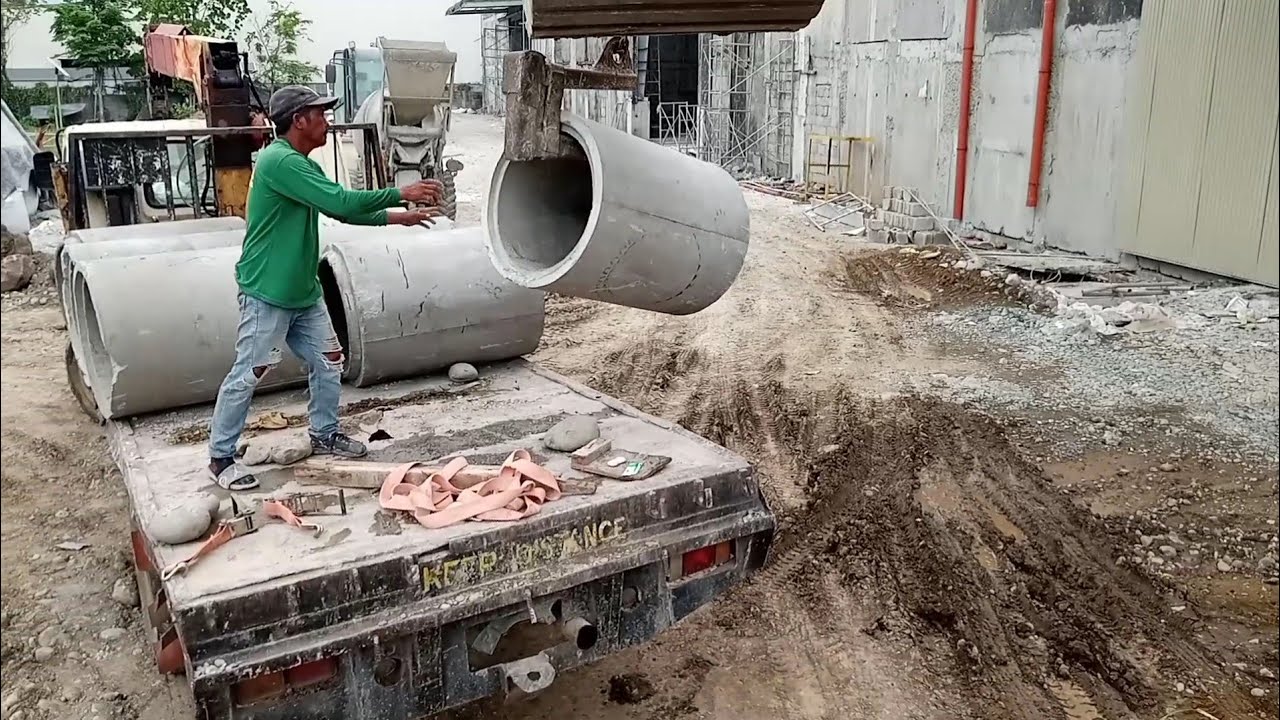 hydraulic excavator loading concrete pipe culvert - YouTube