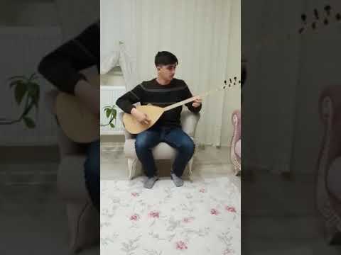 uzun saplı bağlamada Kürtçe şarkı çalmak