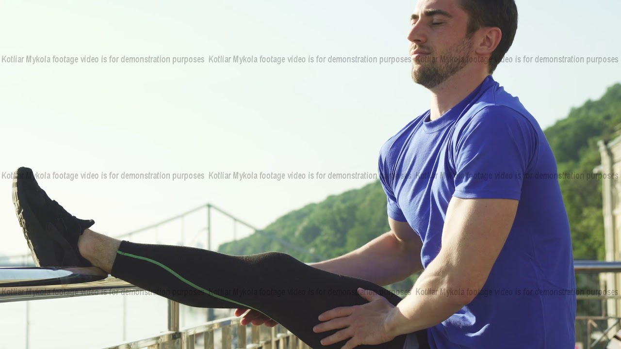 Handsome athletic man stretching his legs before morning outdoor ...