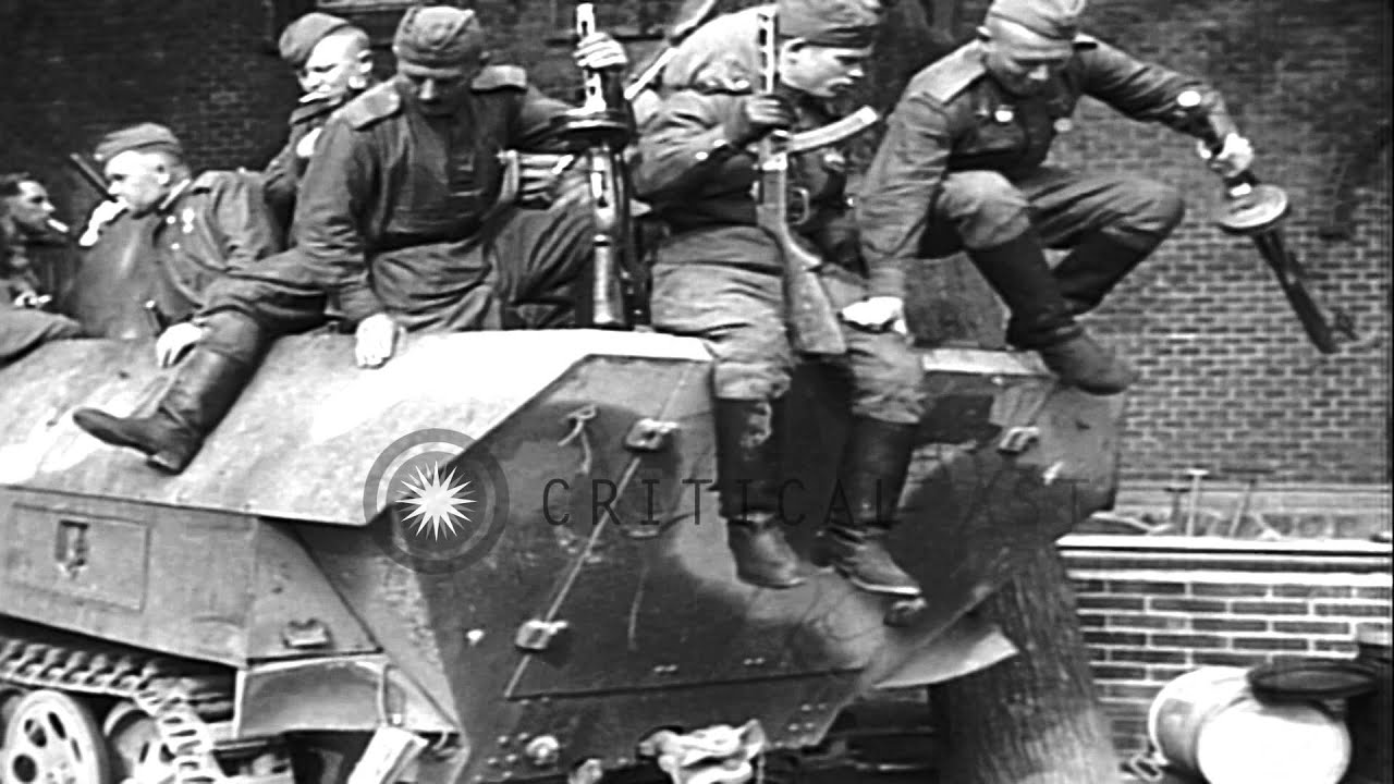 Russian troops riding on captured German half-track in a German town ...