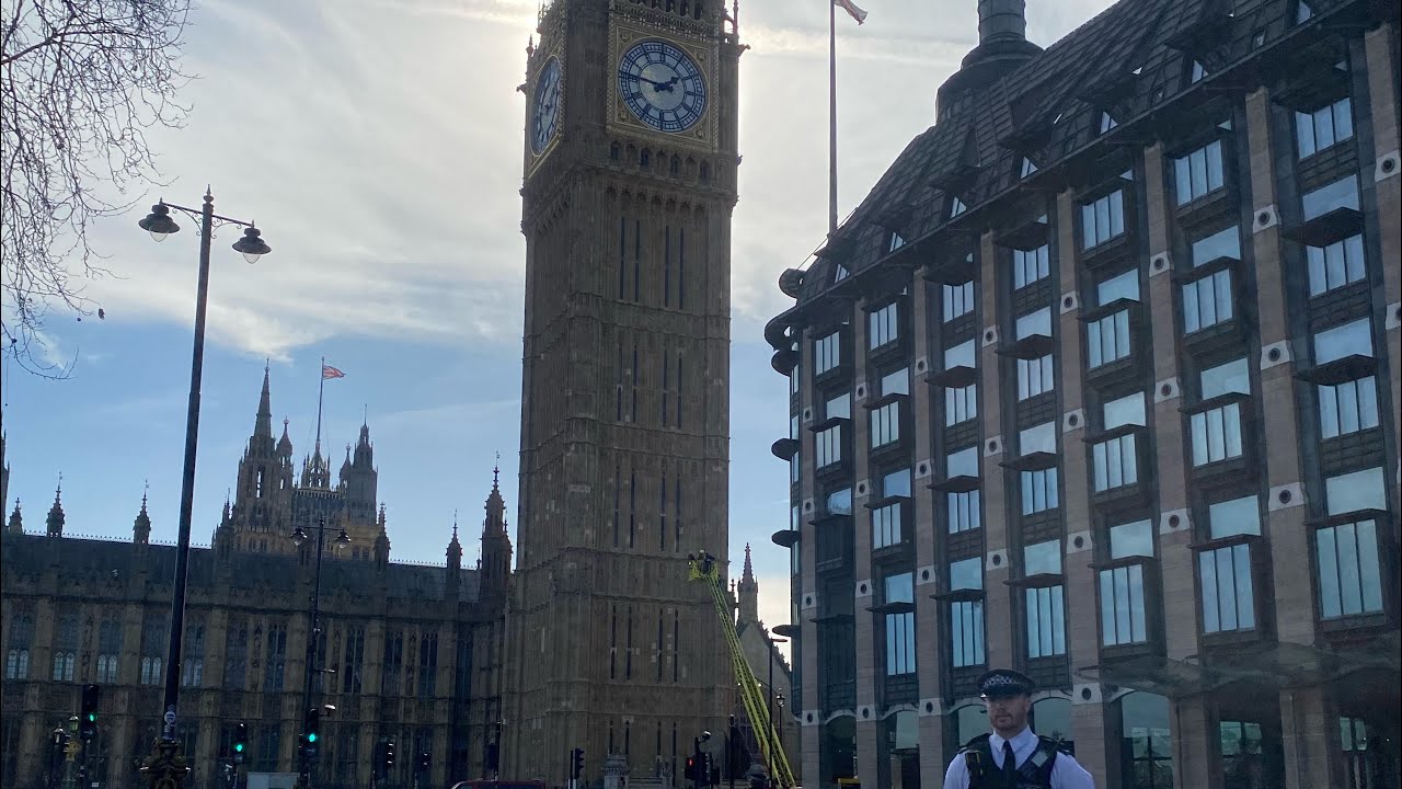 Big Ben chimes throughout the day as protester sits a quarter way up ...