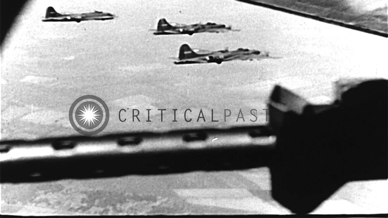 Boeing B-17 Flying Fortresses fly in a formation over enemy terrain in ...