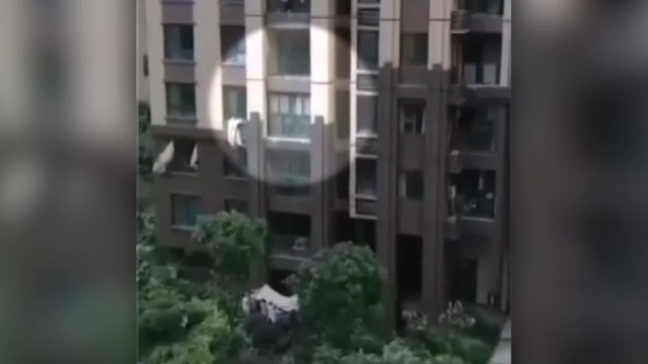 Crowd uses blanket to catch falling child - YouTube