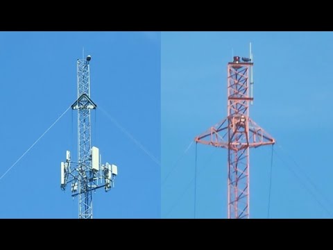A guyed tower with an LED beacon and another guyed tower with a TWR ...