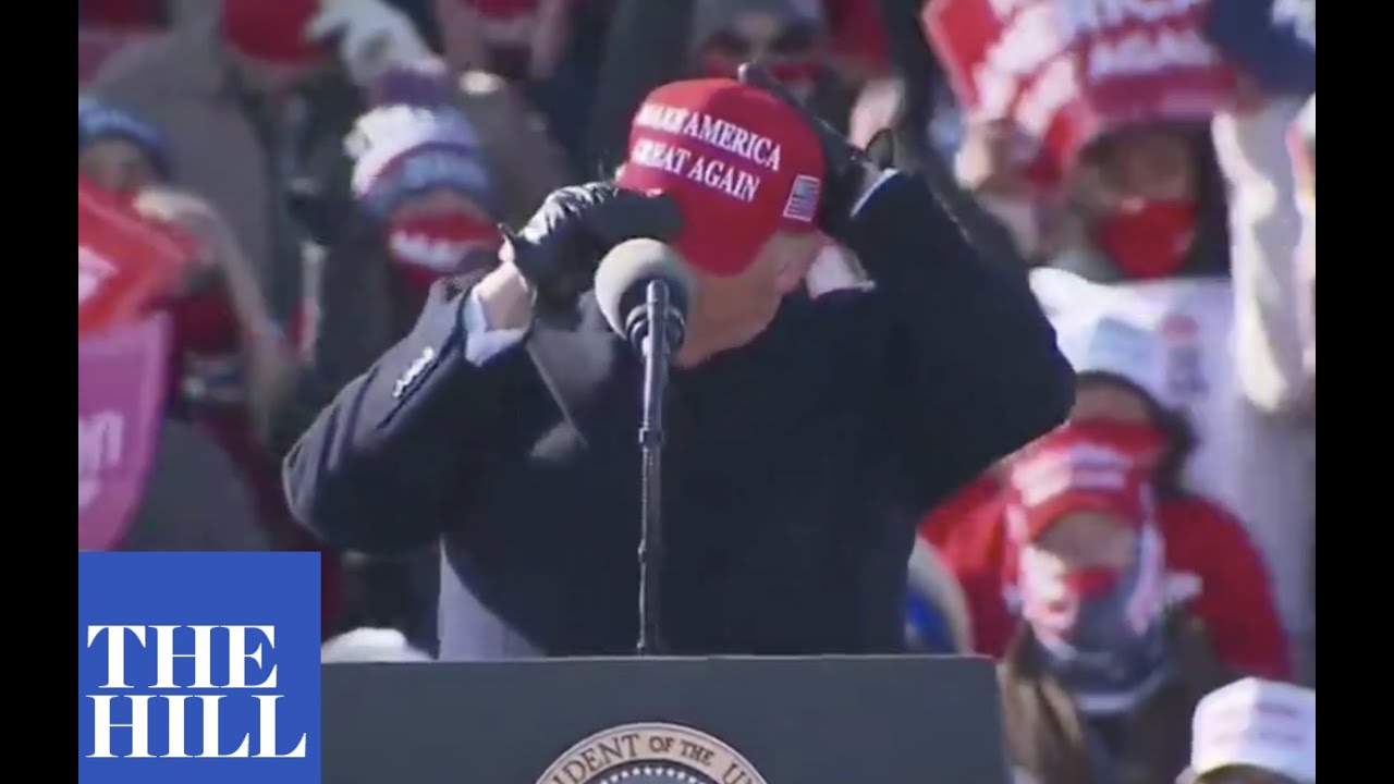 Trump holds onto his MAGA hat during windy rally, mocks Joe Biden in ...
