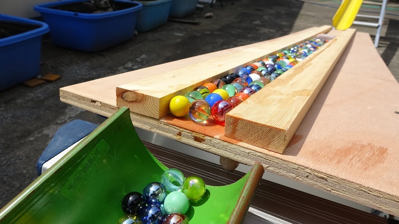 Marble run race - rain gutter + big colorful ball + sandy beach tunnel ...