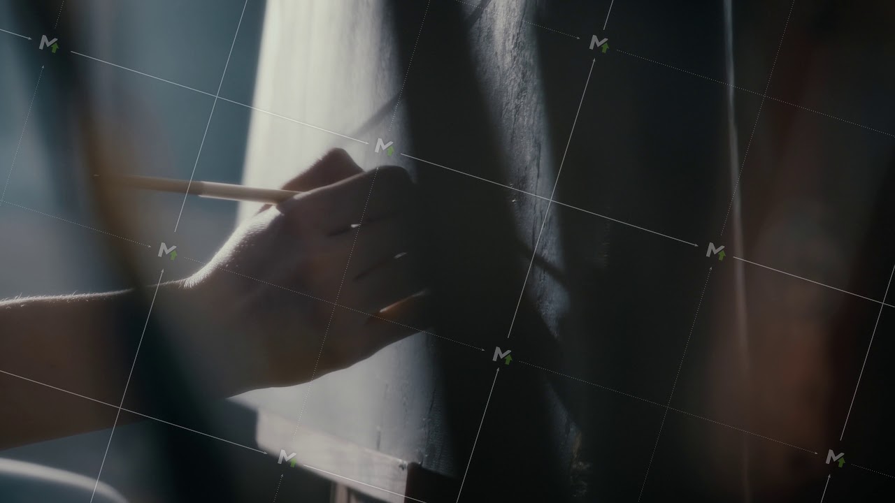 Close-up of the artist holding a brush in her hand and painting on ...