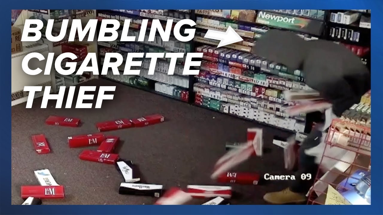 Bumbling cigarette thief repeatedly stumbles and drops all the cartons ...