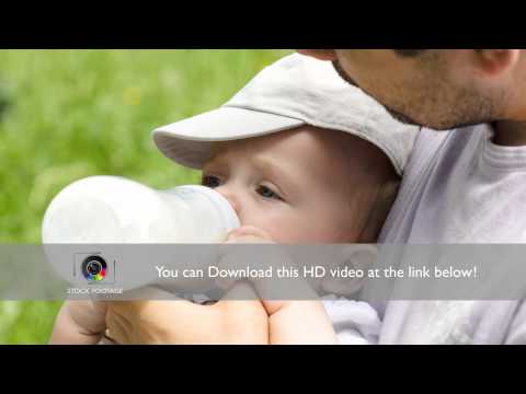 Dad feeding his baby from the bottle outdoor