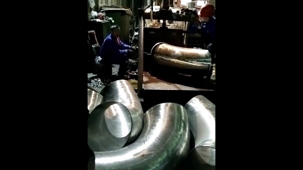 Workers are welding elbows and smoothing weld seam - YouTube