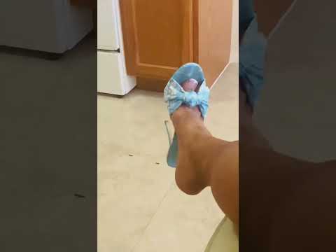 Madam crosses and shakes leg and high heel shoe while supervising servant cleaning floor