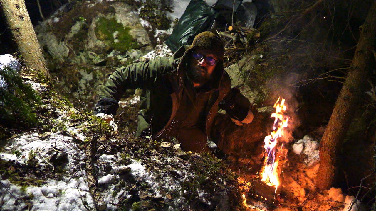 Camping shelter between rocks in the snow at night - Sleep under the ...