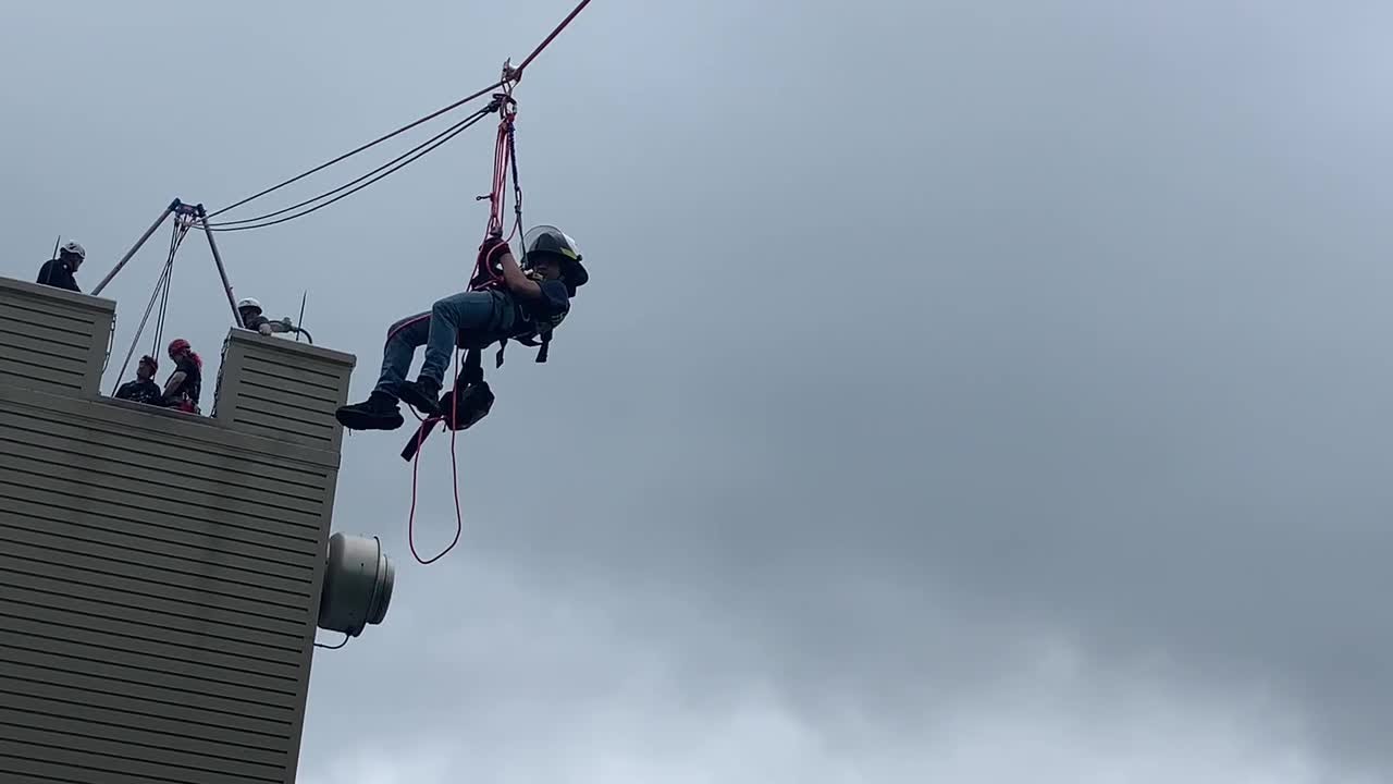 Teen goes down a sloping highline during firefighter training at ...