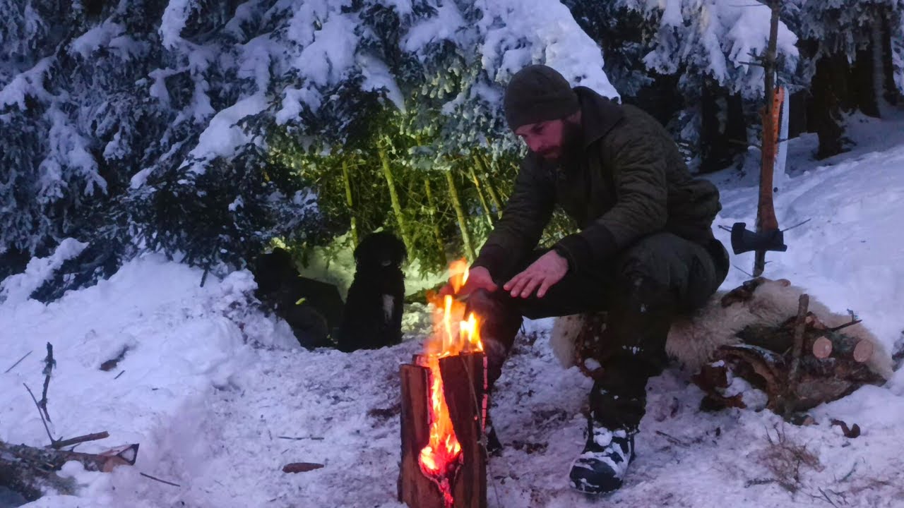 Cold winter bushcraft - primitive survival shelter - swedish torch fire ...