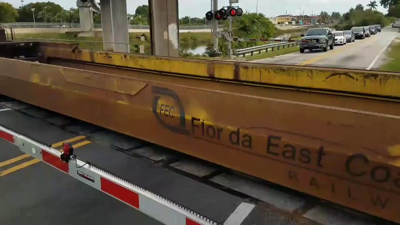 A long FEC train with many of empty well car entering to Hialeah yard ...