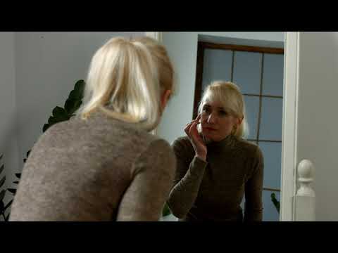Adult woman in the mirror frustrated by her wrinkles