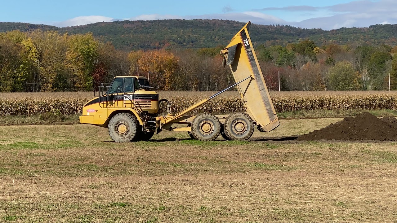 Caterpillar 725 Articulated Dump Truck dumping soil - YouTube